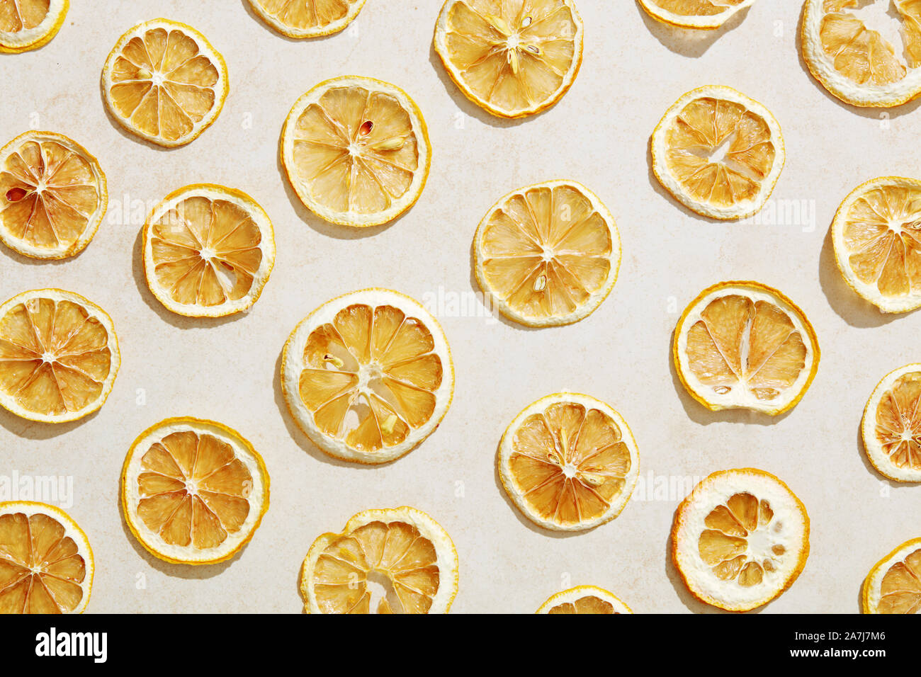 Sun dried lemon slices under hard sunlight with white stone background ...
