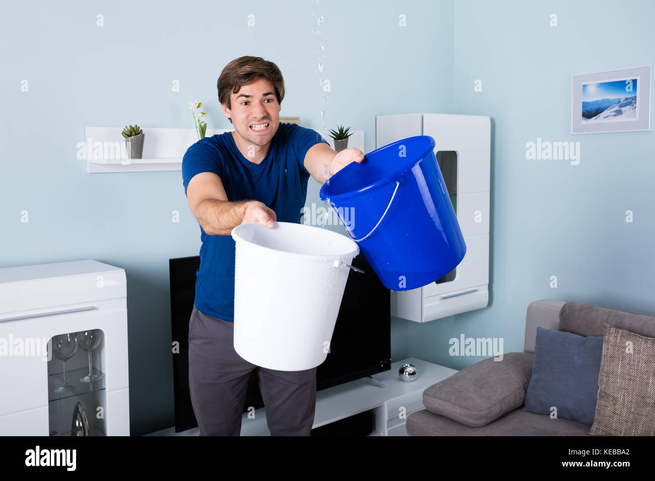 Young Male Worried Man Holding Bucket While Water Droplets Leaking ...