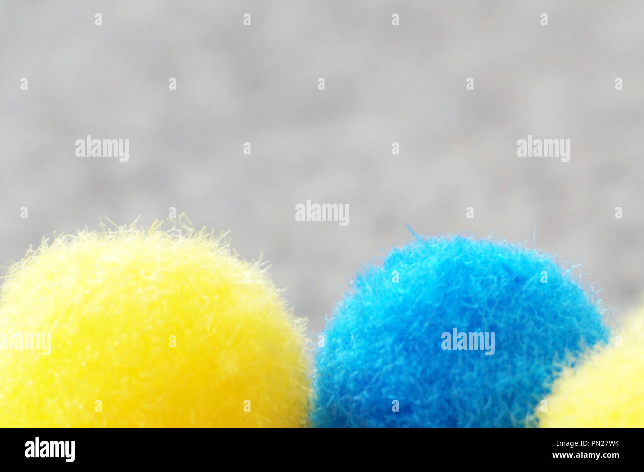 Two wool pom poms close up view on a gray background with free space ...